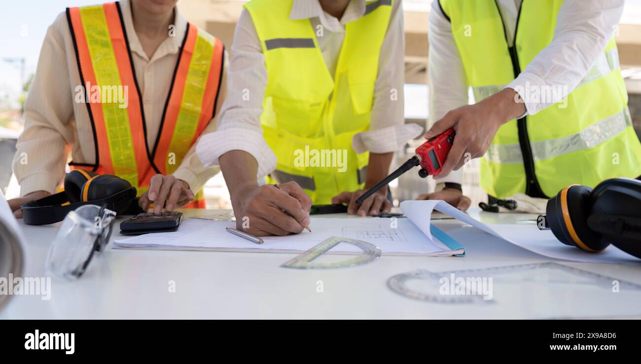 Engineer discussing blueprint at construction site, detail of planning ...