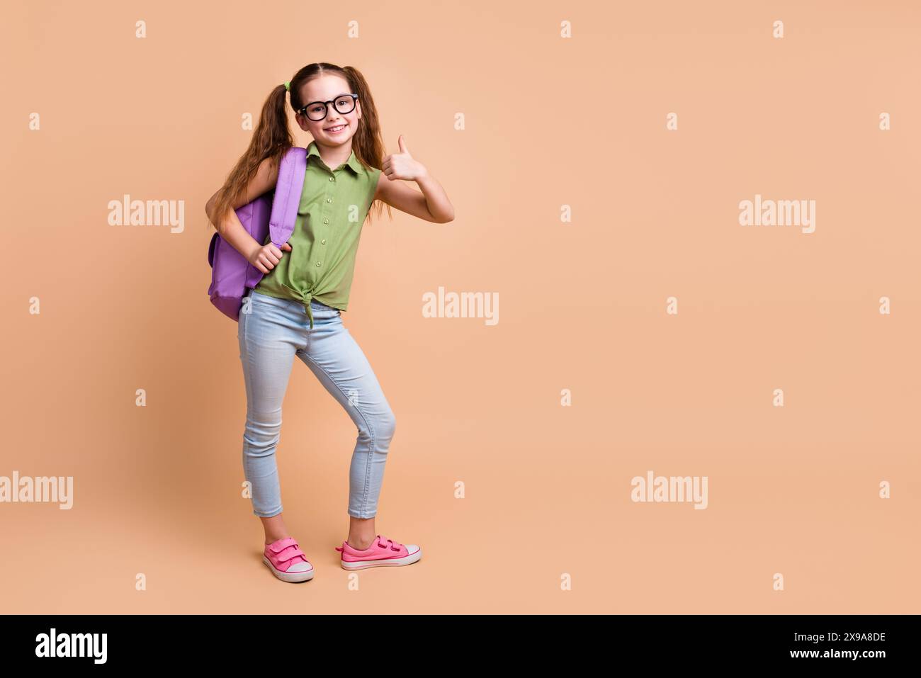 Photo of positive girl kid stand near empty space make thumb up ...