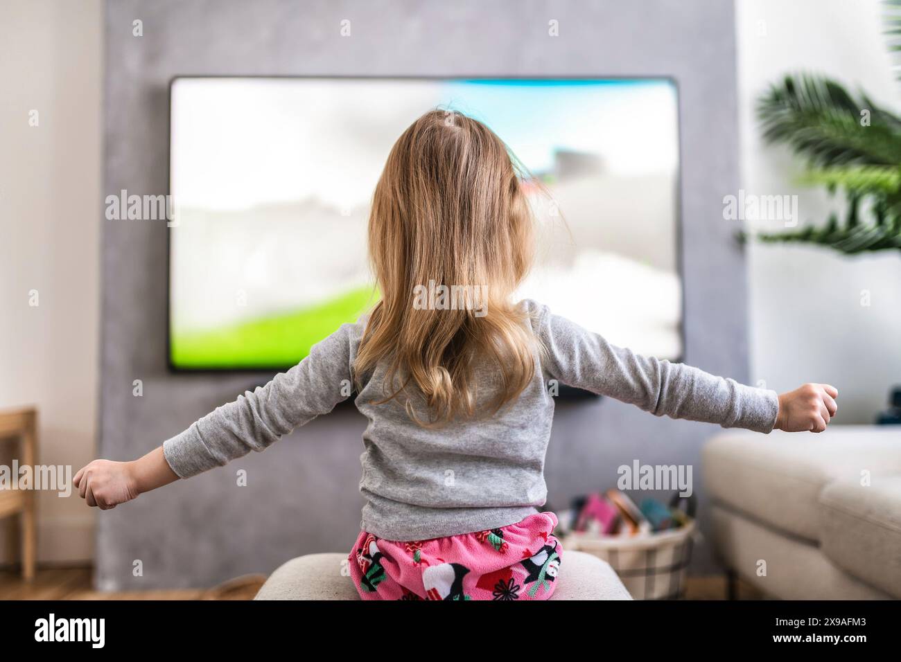girl listening television and watching cartoon at home. Selected focus ...