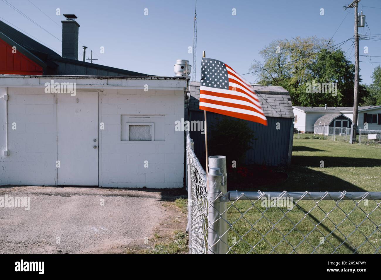 A small flag on a chain-link fence in Lexington Heights Michigan USA ...