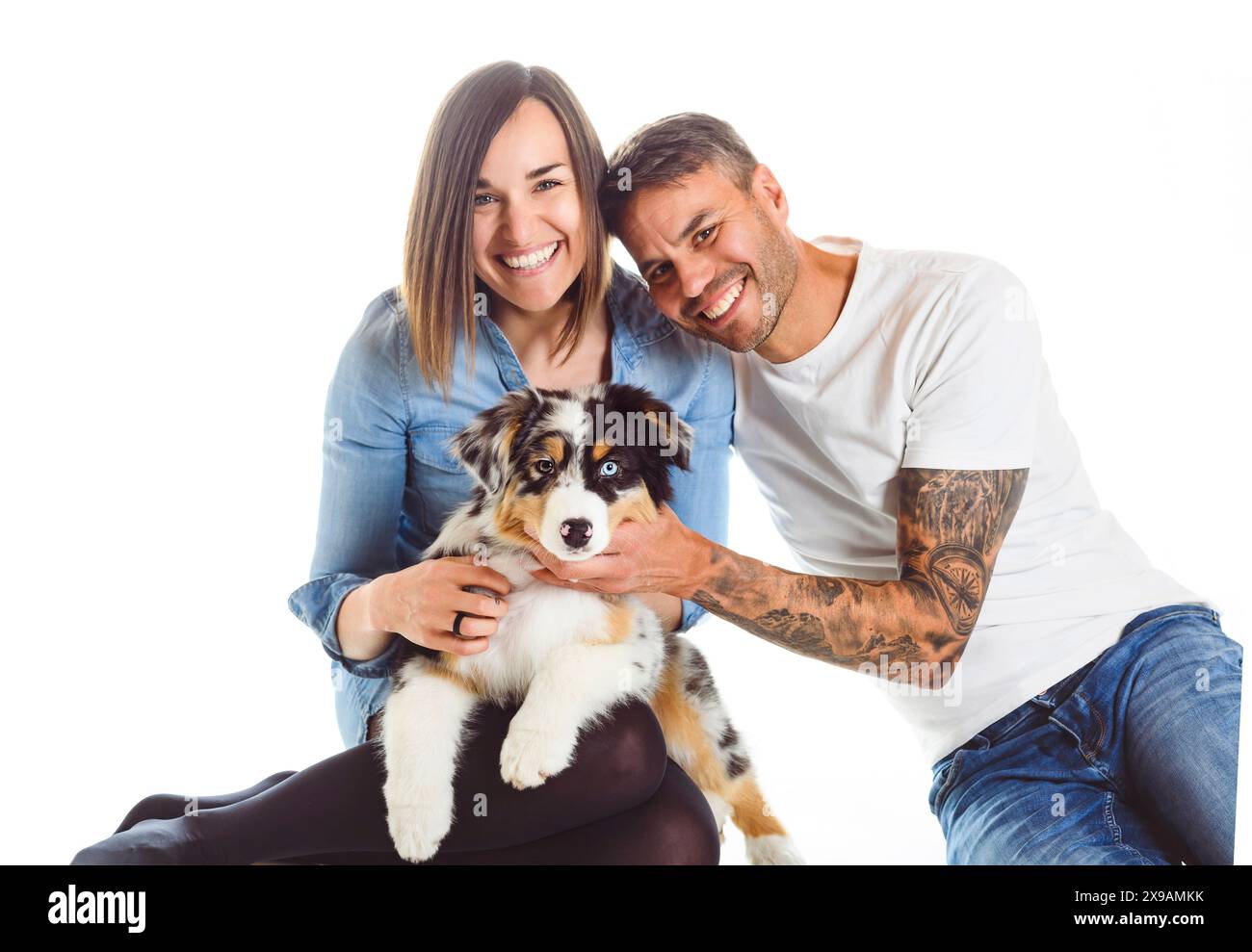 Handsome couple with her Australian Berger puppy on studio Stock Photo ...