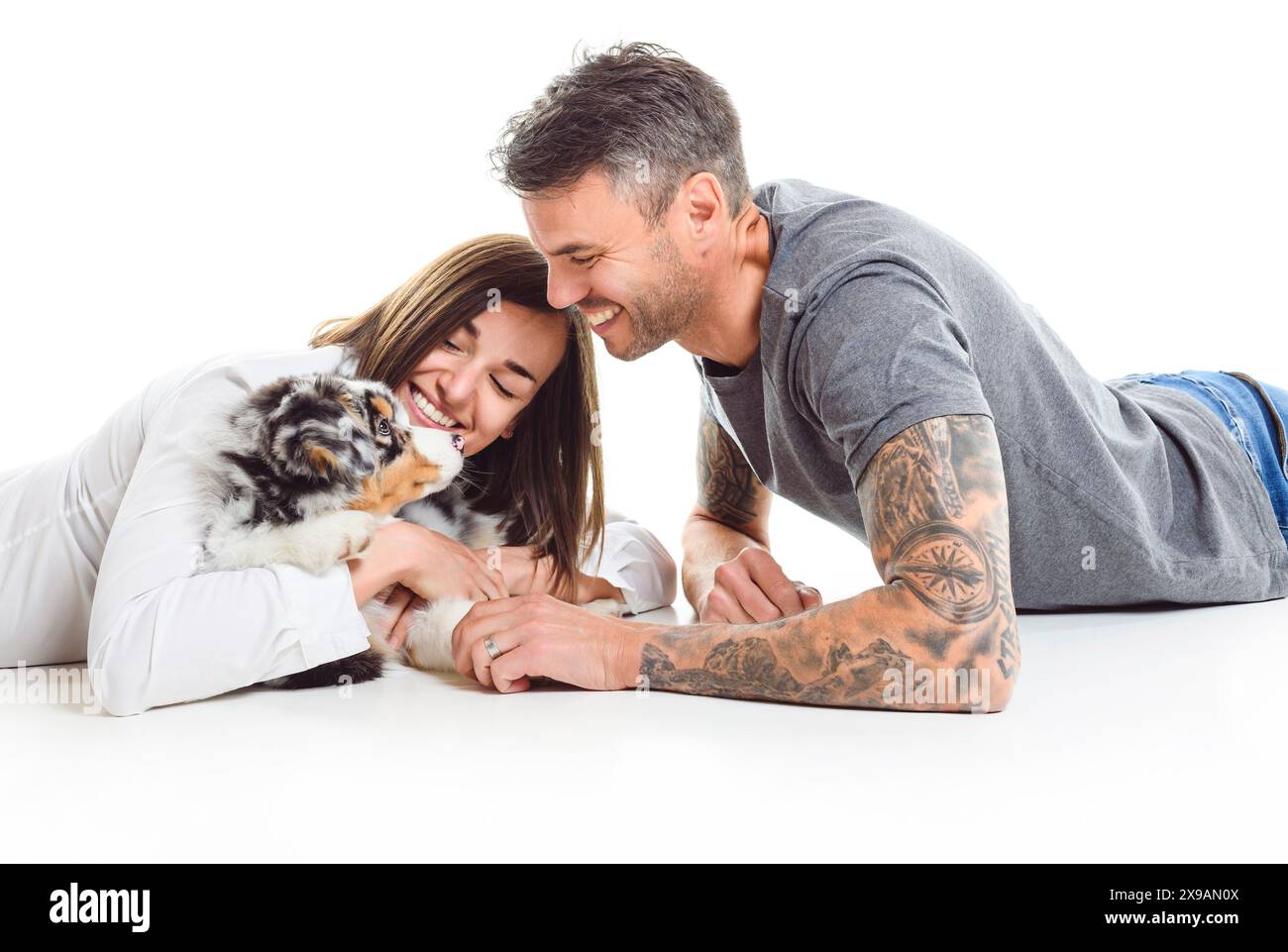 Handsome couple with her Australian Berger puppy on studio Stock Photo ...