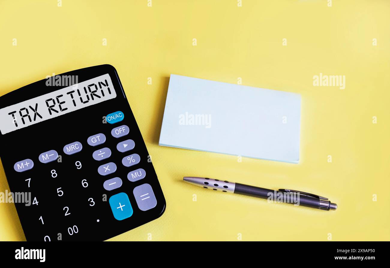 Calculator display with text TAX RETURN, on a yellow background ...