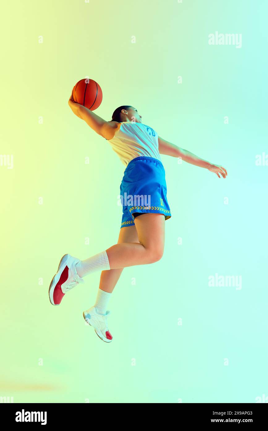 Low angle of basketball player leaping in motion to make perfect goal ...
