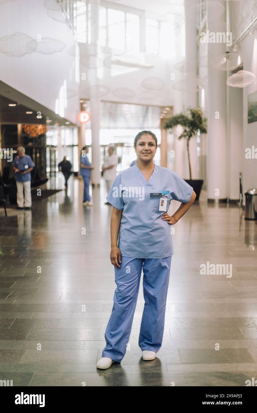 Full length portrait of confident female doctor standing with hand on ...