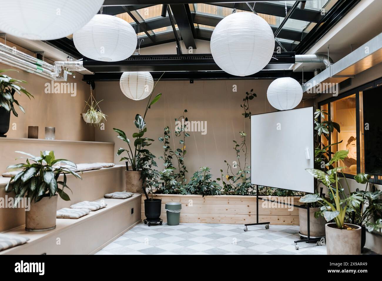 Modern interior of coworking space with whiteboard and plants Stock ...