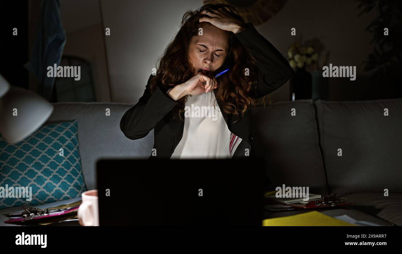 A stressed woman working late at home, exhausted from her tasks ...