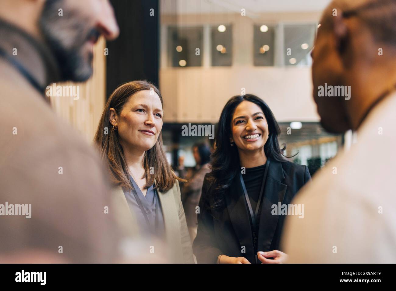 Female entrepreneurs talking with male delegates during networking ...