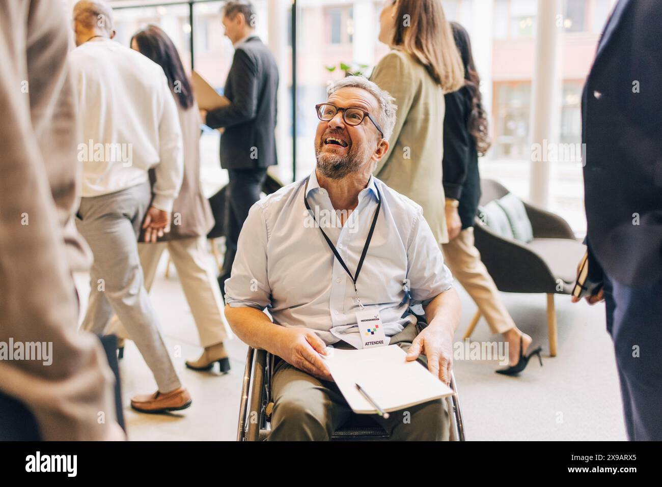 Smiling male entrepreneur with disability sitting on wheelchair during ...