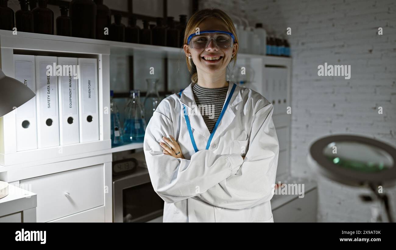 A confident woman scientist crossing arms stands indoors at a ...