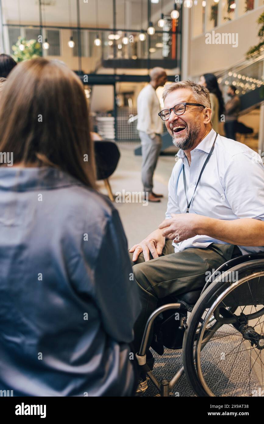 Happy male entrepreneur with disability sitting on wheelchair during ...