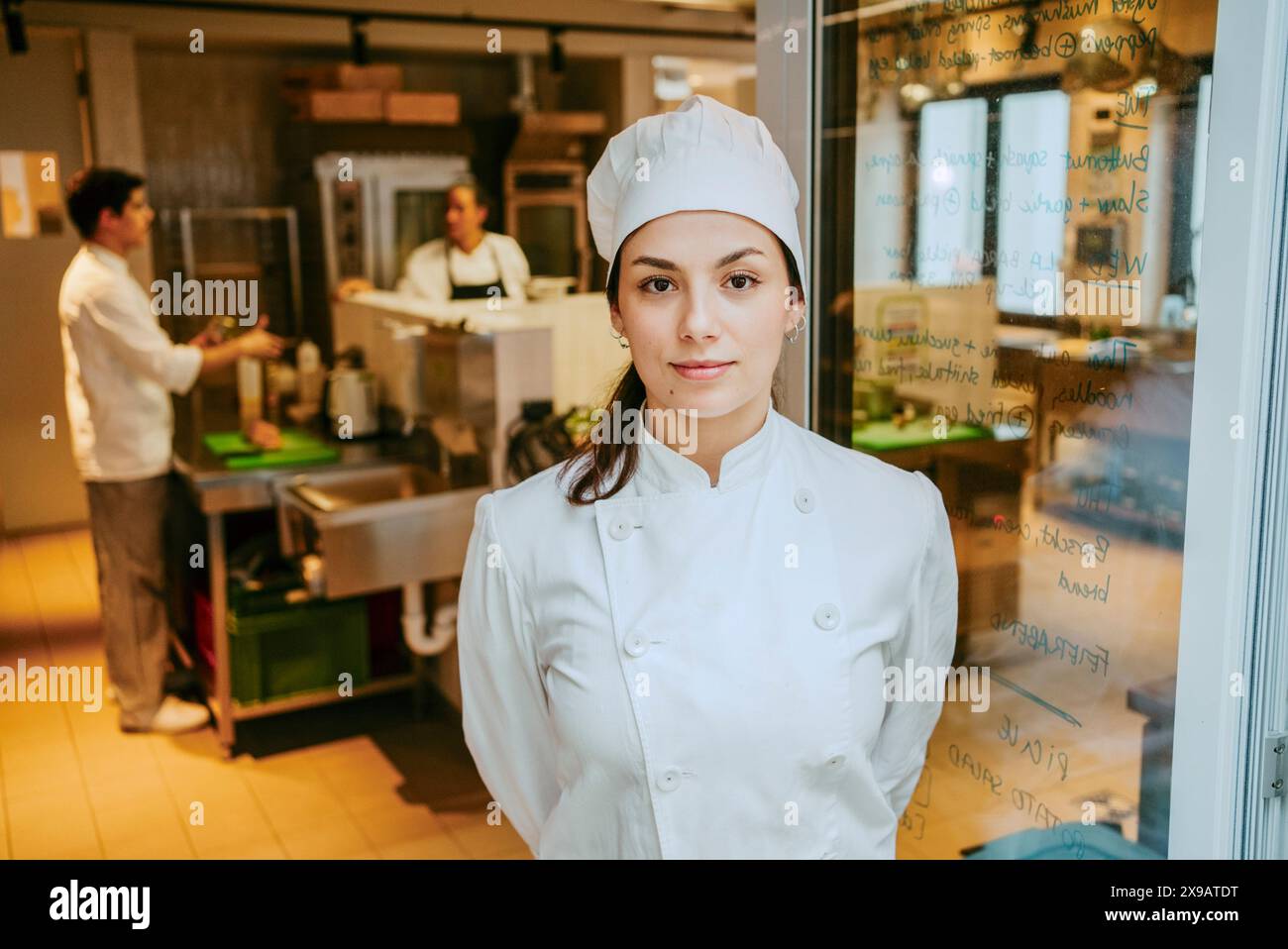 Portrait of female chef standing at door of commercial kitchen Stock ...