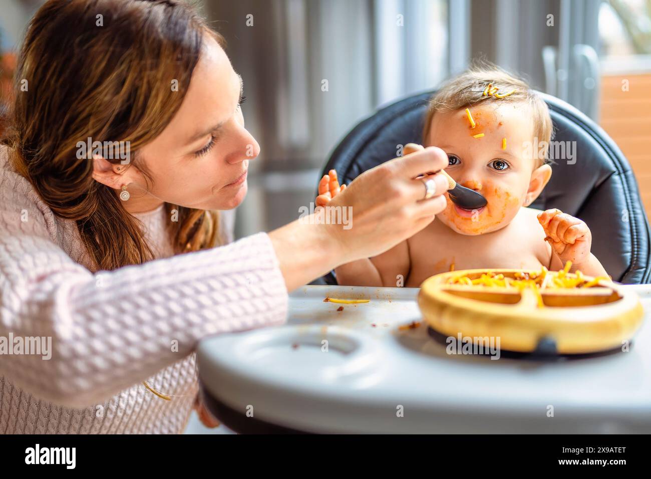 Little baby girl eating her dinner with her mother Stock Photo - Alamy