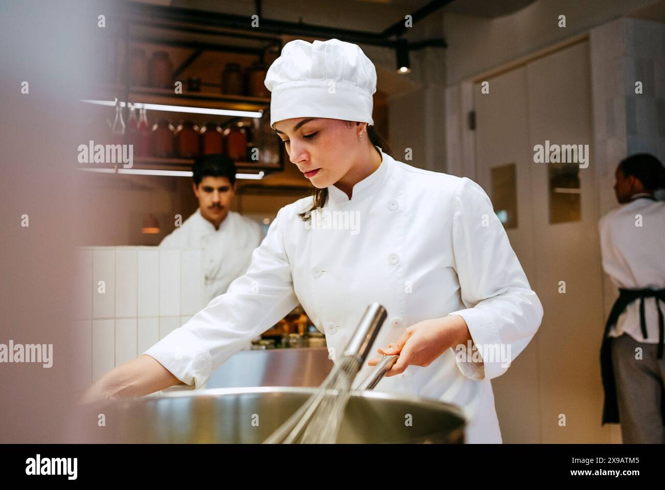 Female chef cooking food at commercial kitchen Stock Photo - Alamy