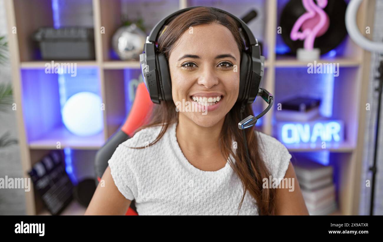 Young beautiful hispanic woman streamer wearing headset smiling at ...
