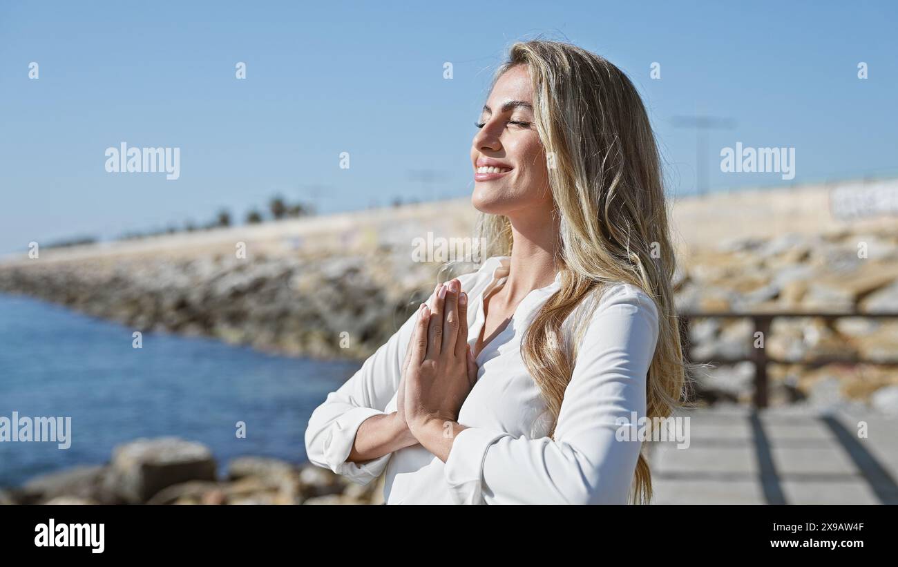Radiant young blonde woman finds balance and freedom, praying with a ...