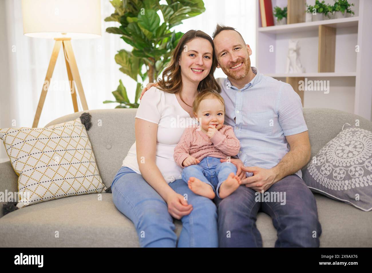 Portrait of a young happy family with the kid at home Stock Photo - Alamy