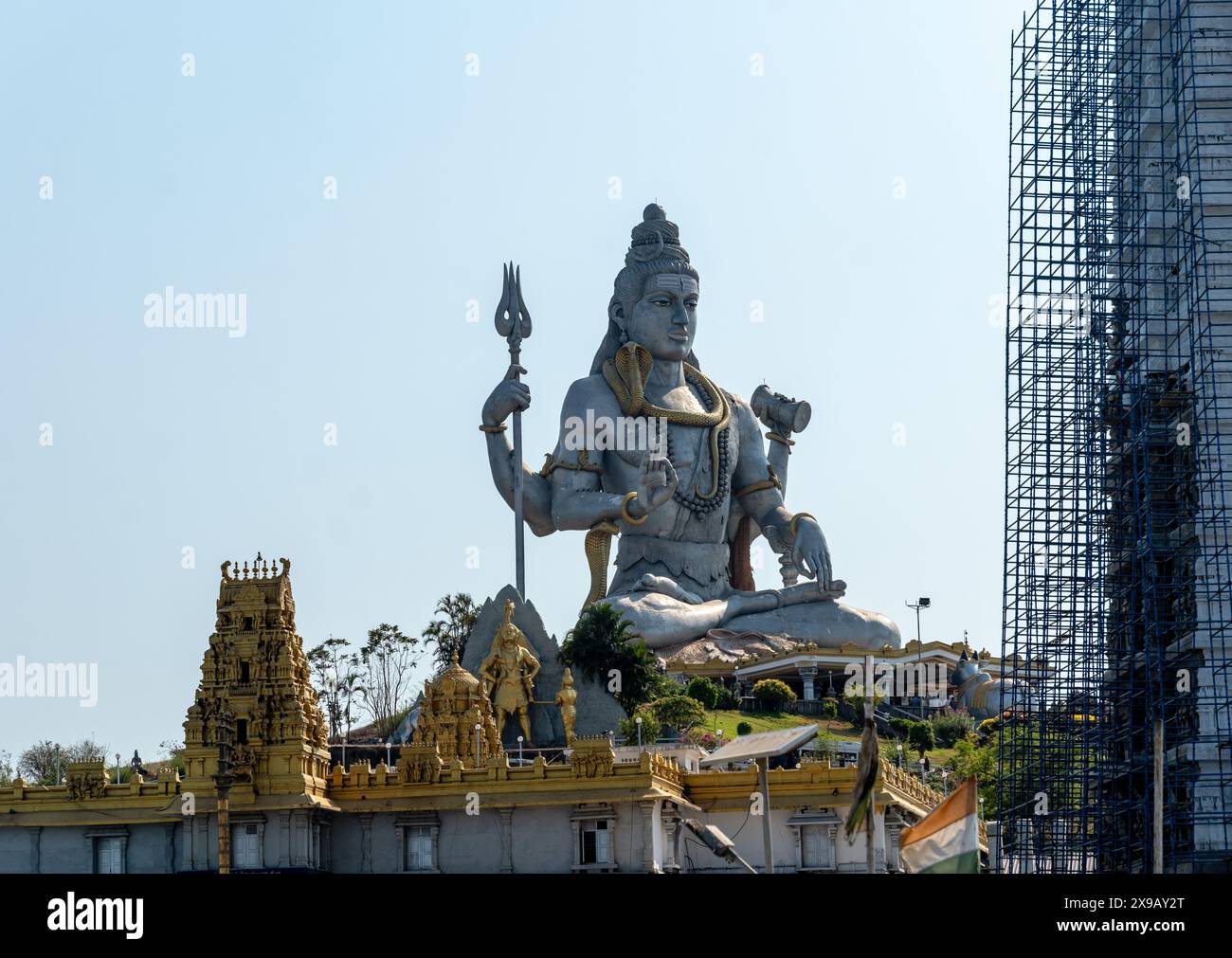 A grand sculpture of Lord Shiva, with multiple arms and a serene ...