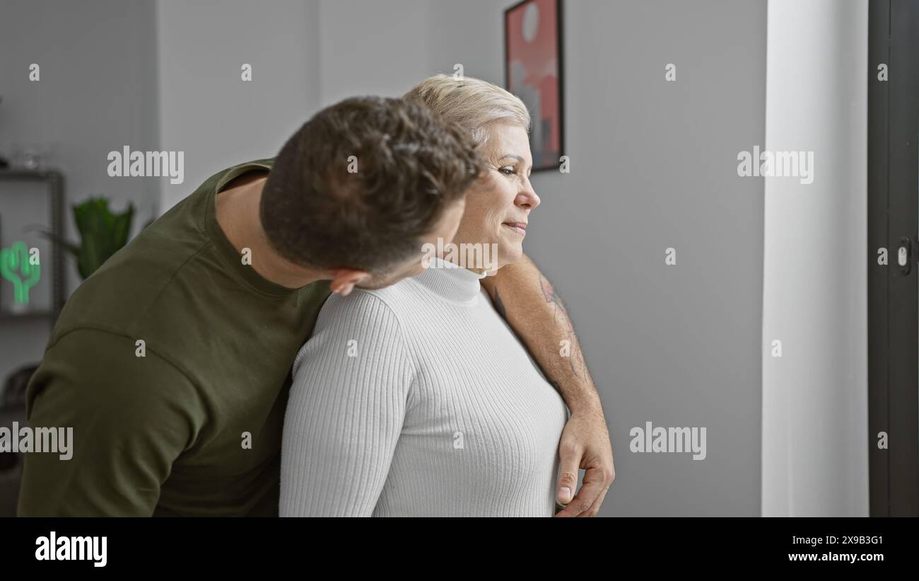 A tender moment as a young man embraces an older woman in a cozy modern ...