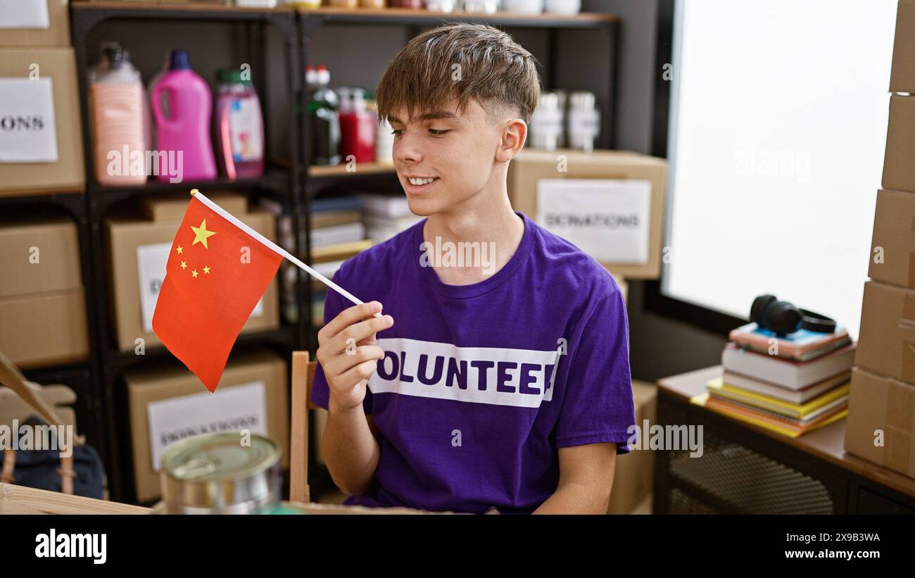 Teen boy volunteer holds chinese flag in a warehouse filled with ...