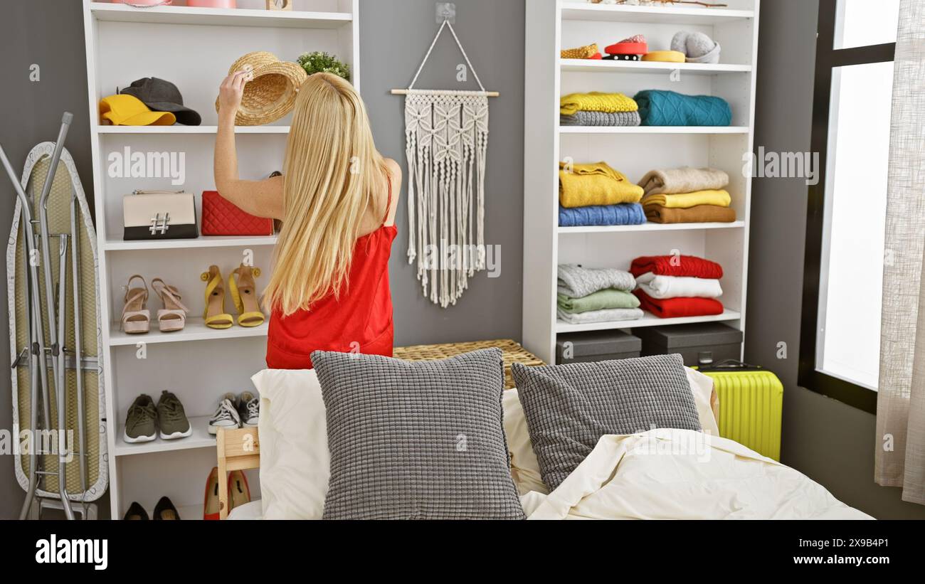 Blonde woman organizing wardrobe in a modern bedroom interior at home ...