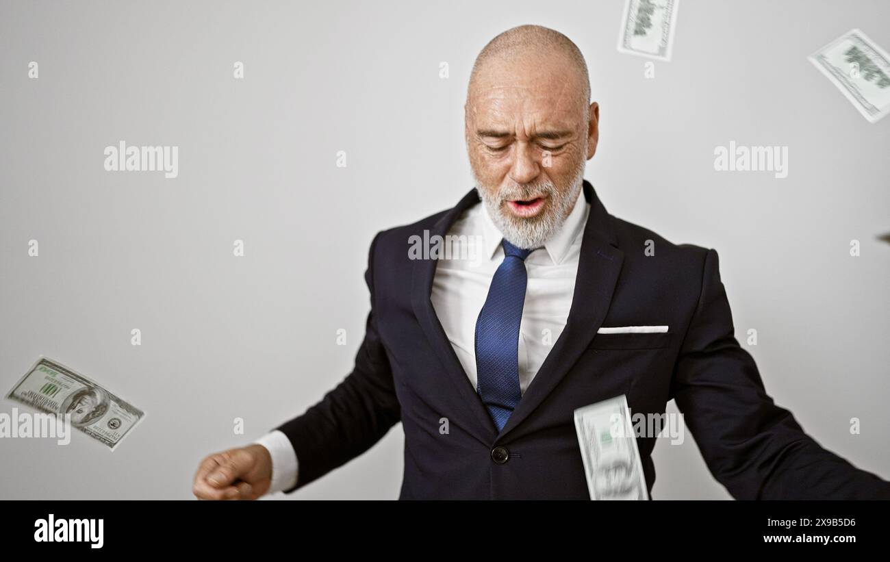 Mature bald man in suit grimacing with falling dollars against a white ...