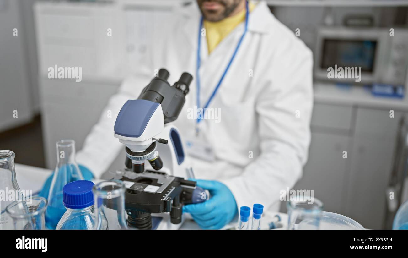 Professional man in lab coat using microscope in a laboratory setting ...