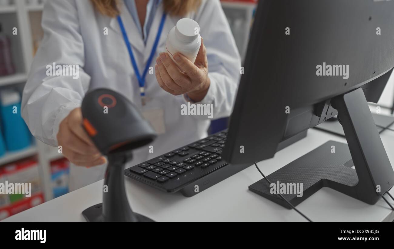 A woman pharmacist scans a medication bottle at the pharmacy counter ...