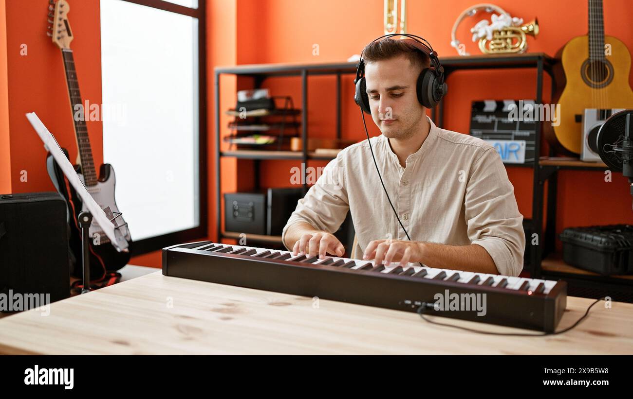 Handsome hispanic man playing keyboard indoors at a music studio Stock ...