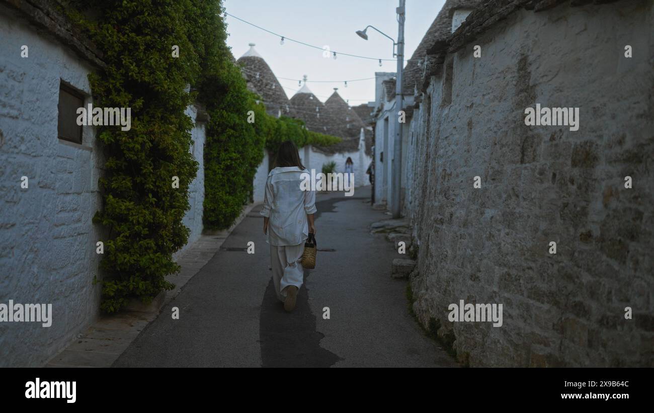 A young hispanic woman walks alone through the charming streets of ...