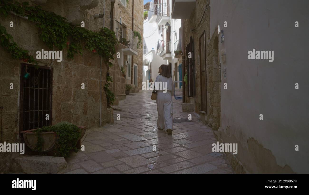 A young hispanic woman walks through the picturesque cobblestone ...