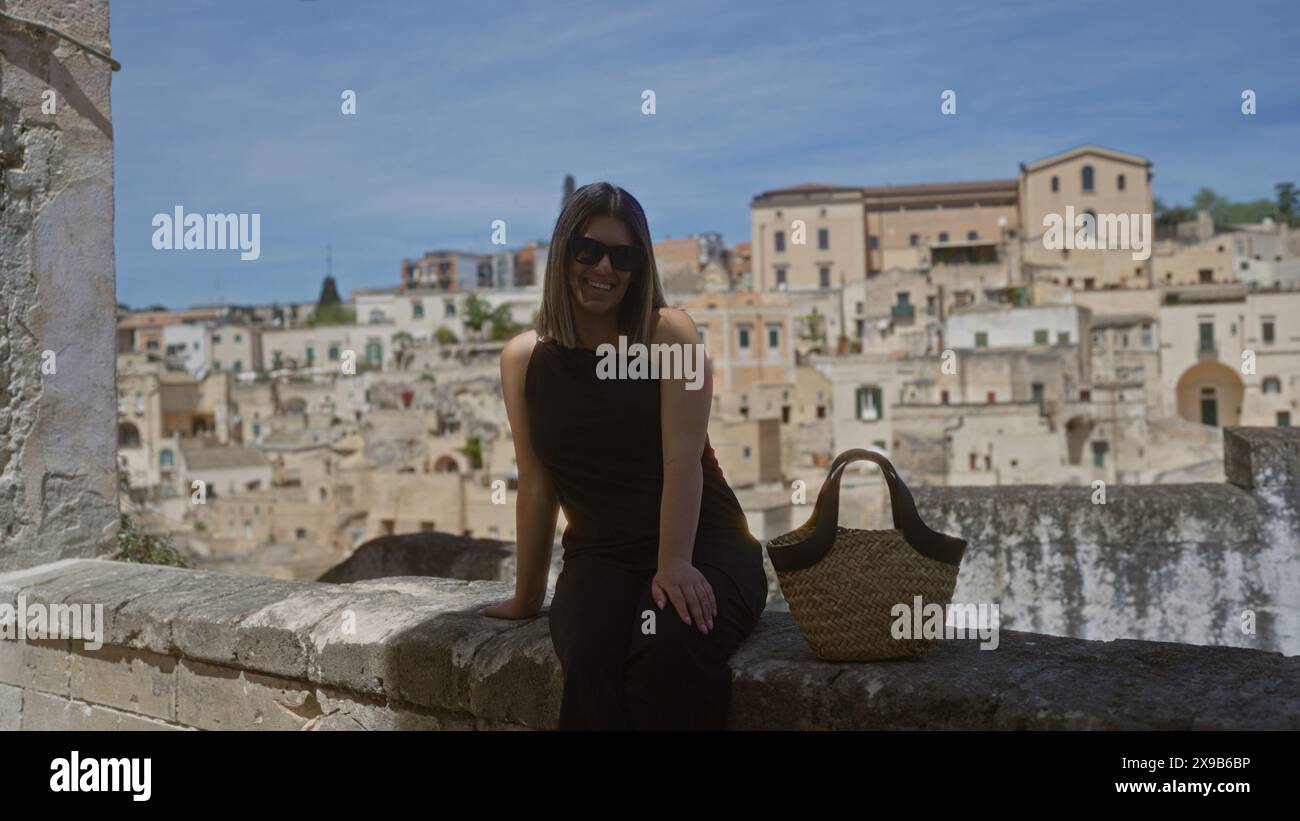 A beautiful young hispanic woman sitting at a viewpoint in the old town ...