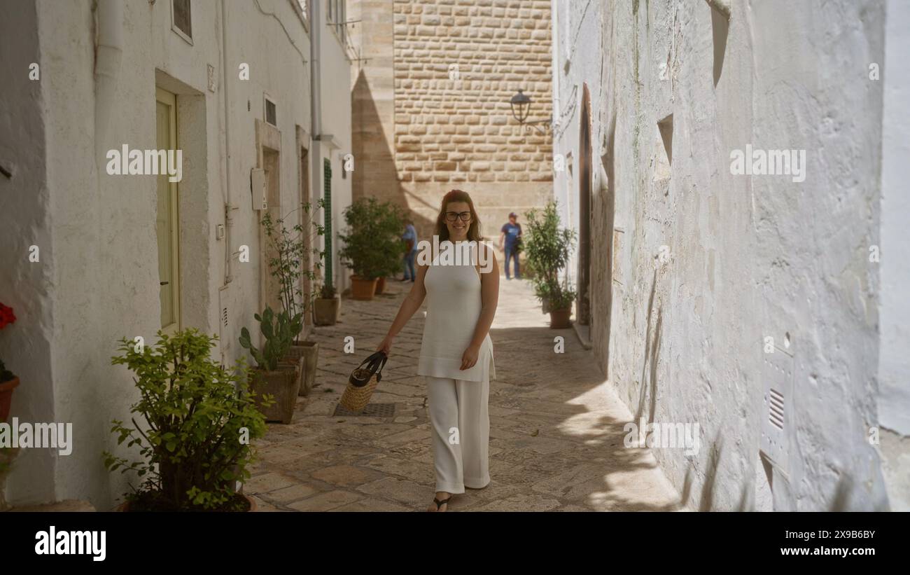 A beautiful young hispanic woman walks through the charming old town ...