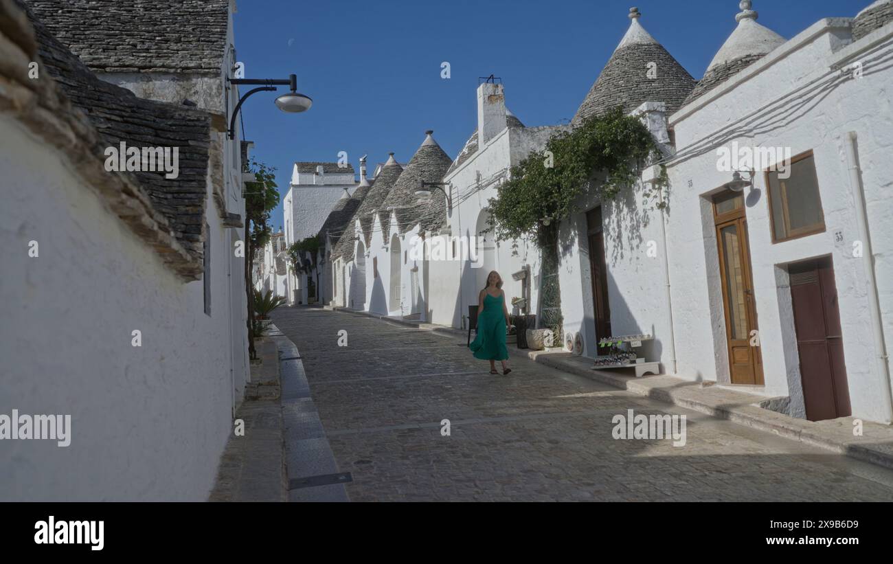 Young hispanic woman walks down a charming street in the old town of ...