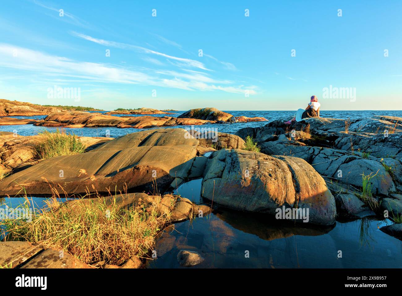 Woman sitting on shore sunset hi-res stock photography and images - Alamy