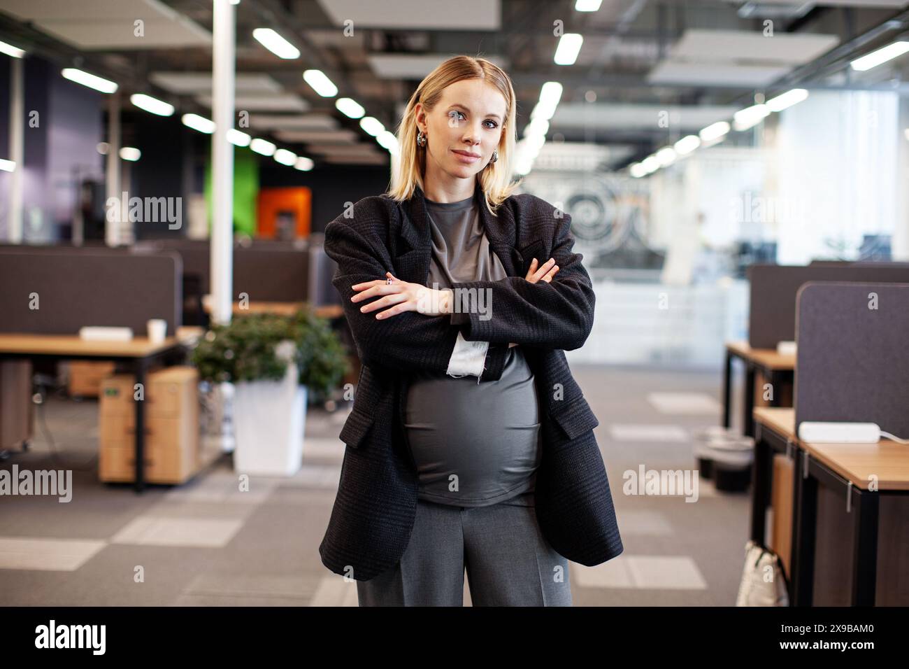 Pregnant woman in a modern office, balancing career responsibilities ...