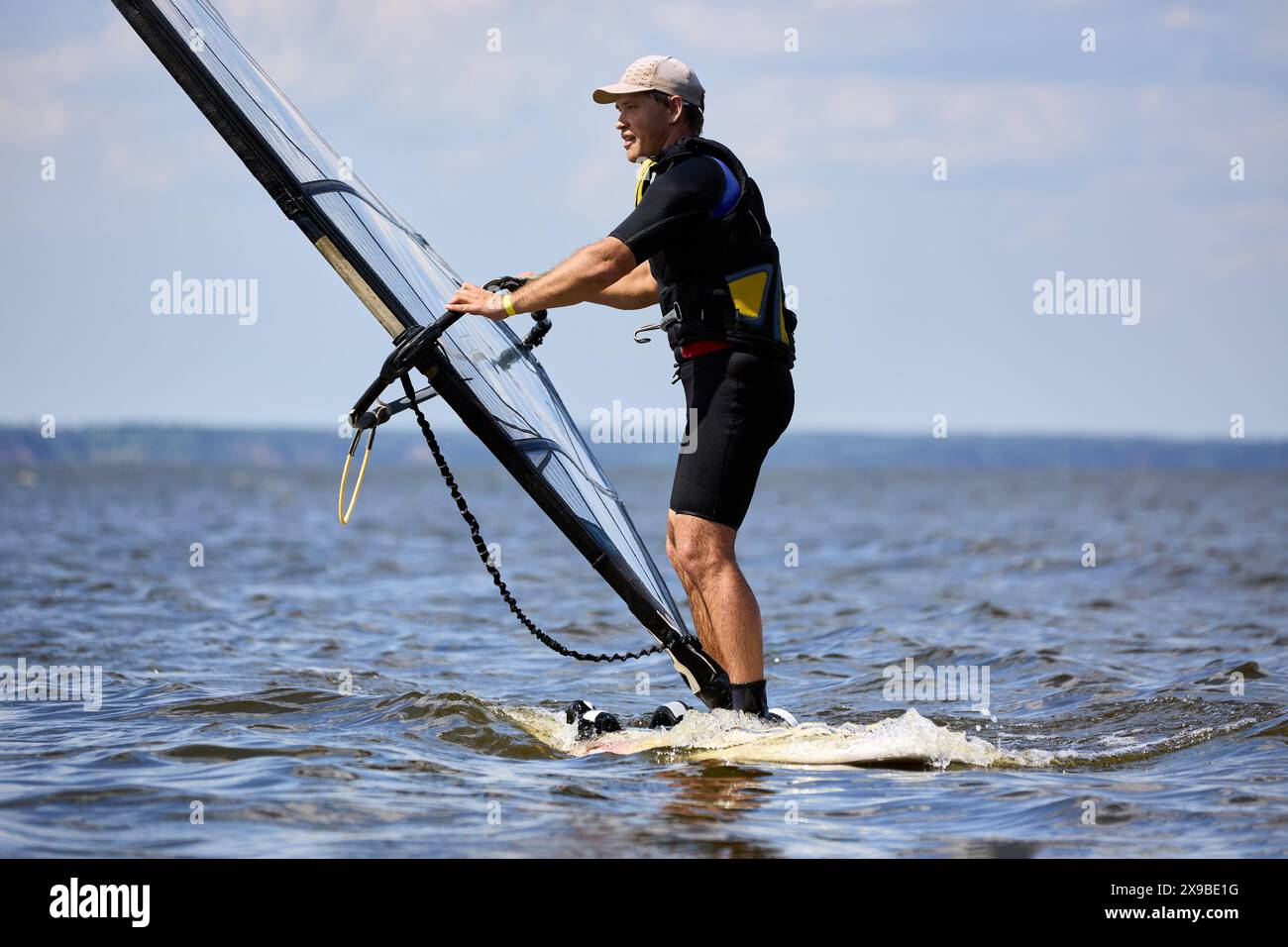 Side view of a windsurfer passing by Stock Photo - Alamy