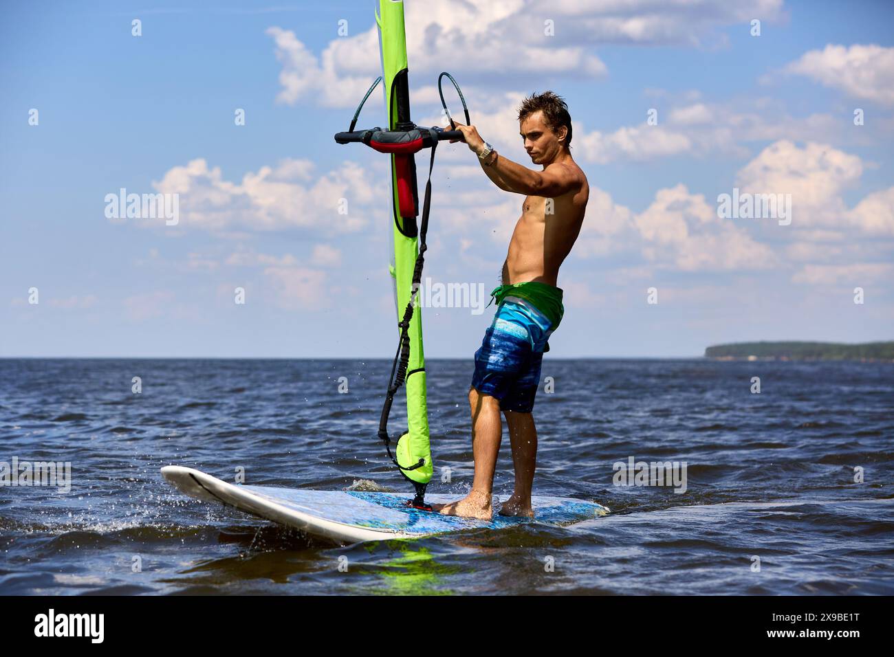 Side view of a windsurfer passing by Stock Photo - Alamy