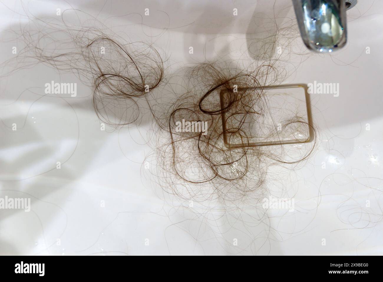 Close up reveals a sink covered in strands of hair. Tangled Remnants ...