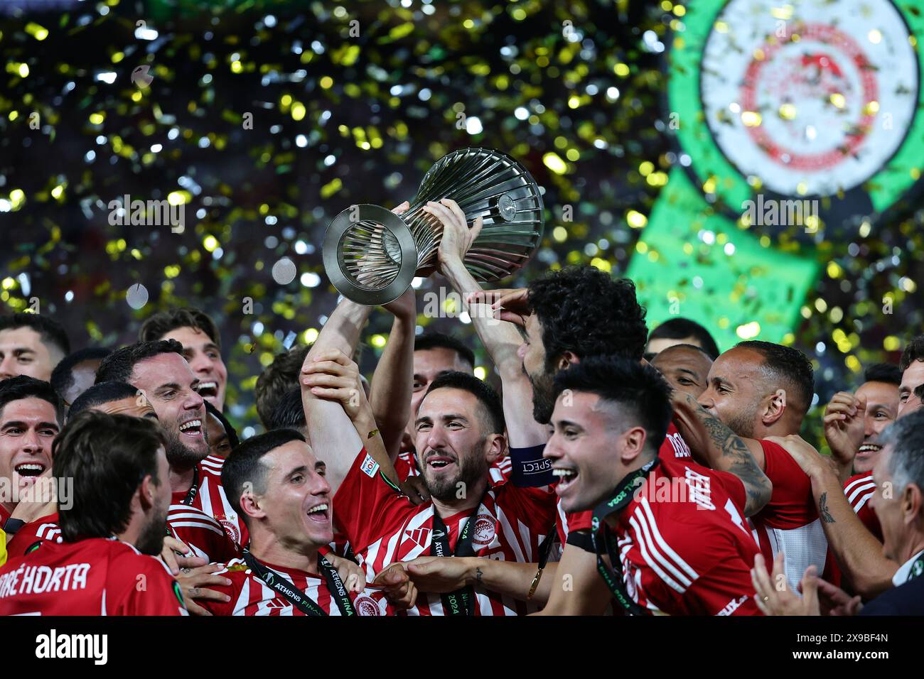 Olympiacos players celebrate victory with the trophy at the end the ...