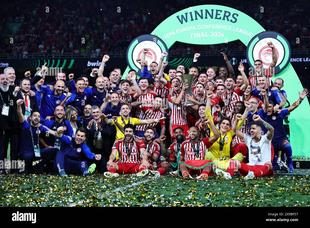 Olympiacos players celebrate victory with the trophy at the end the ...