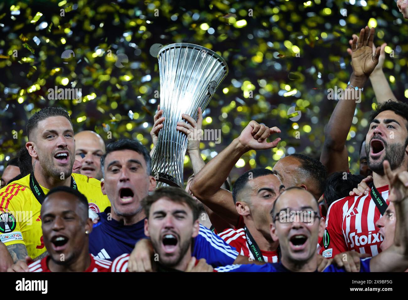 Olympiacos players celebrate victory with the trophy at the end the ...