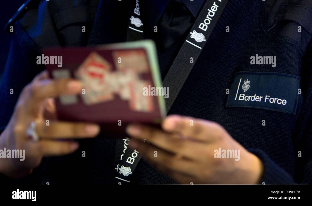 File photo dated 04/06/14 of a Border Force officer checking a passport ...