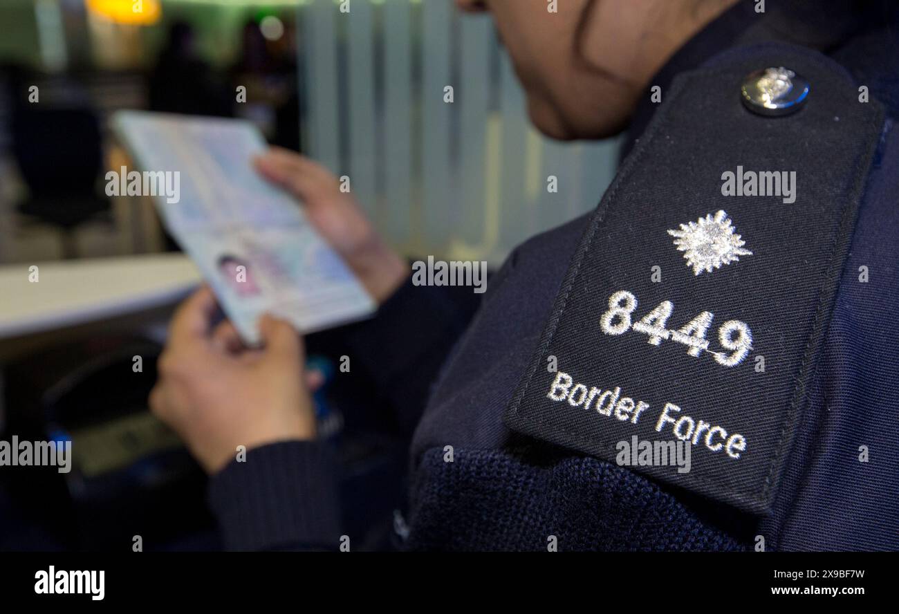 File photo dated 04/06/14 of a Border Force officer checking a passport ...