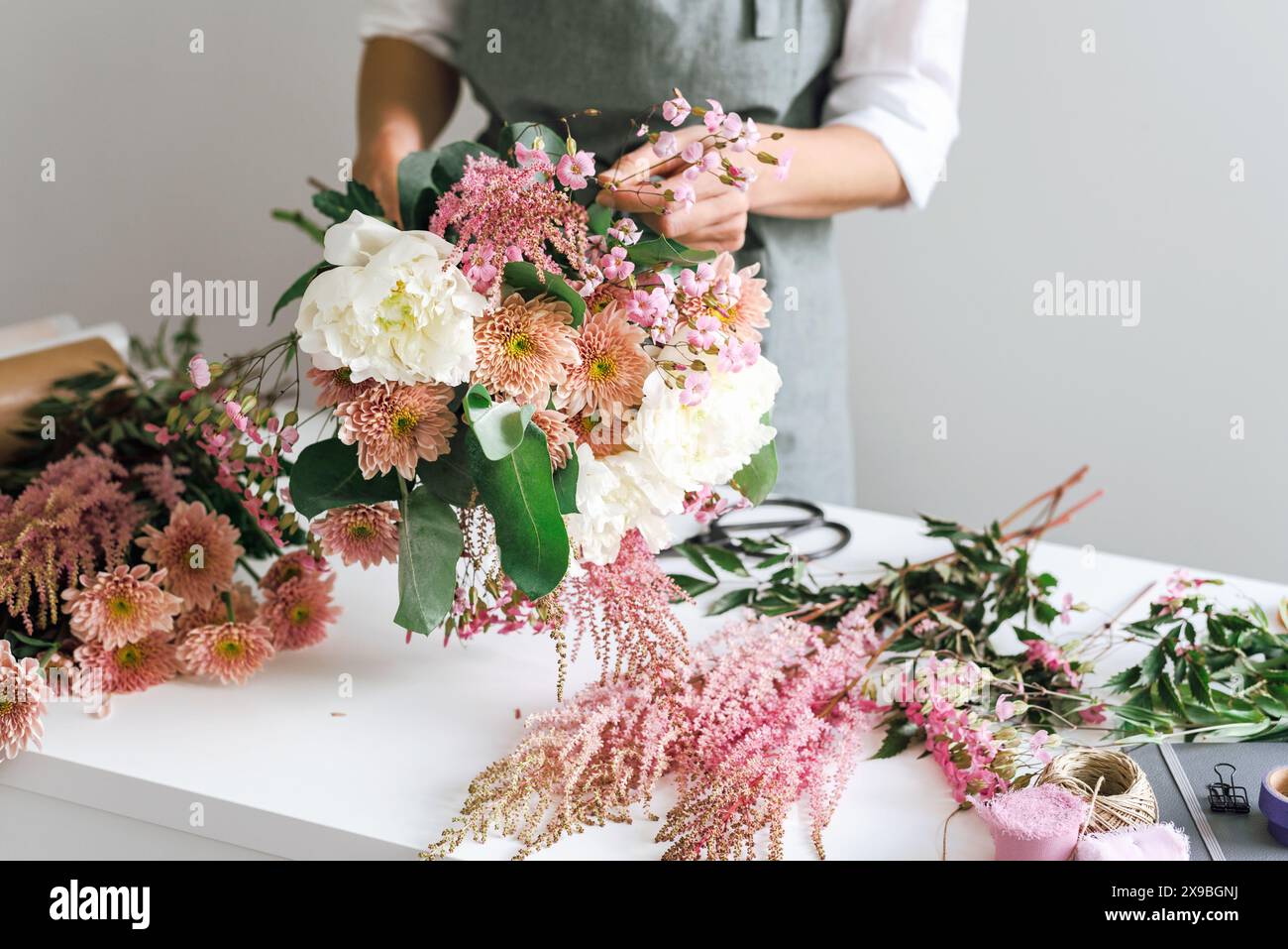 A flower boutique employee creates a flower arrangement Stock Photo - Alamy