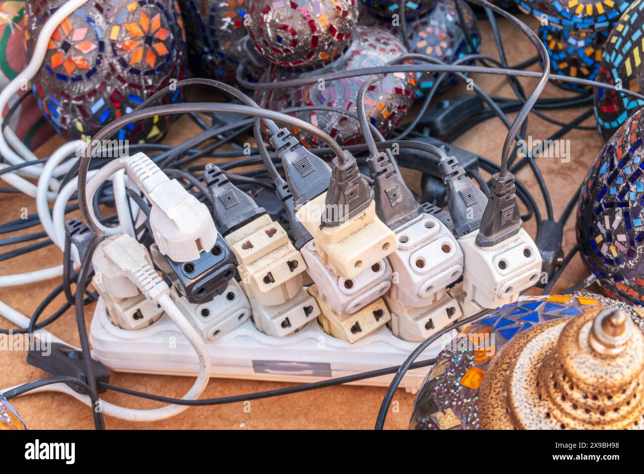 Old and damaged electric adapter power plug has many appliances are ...