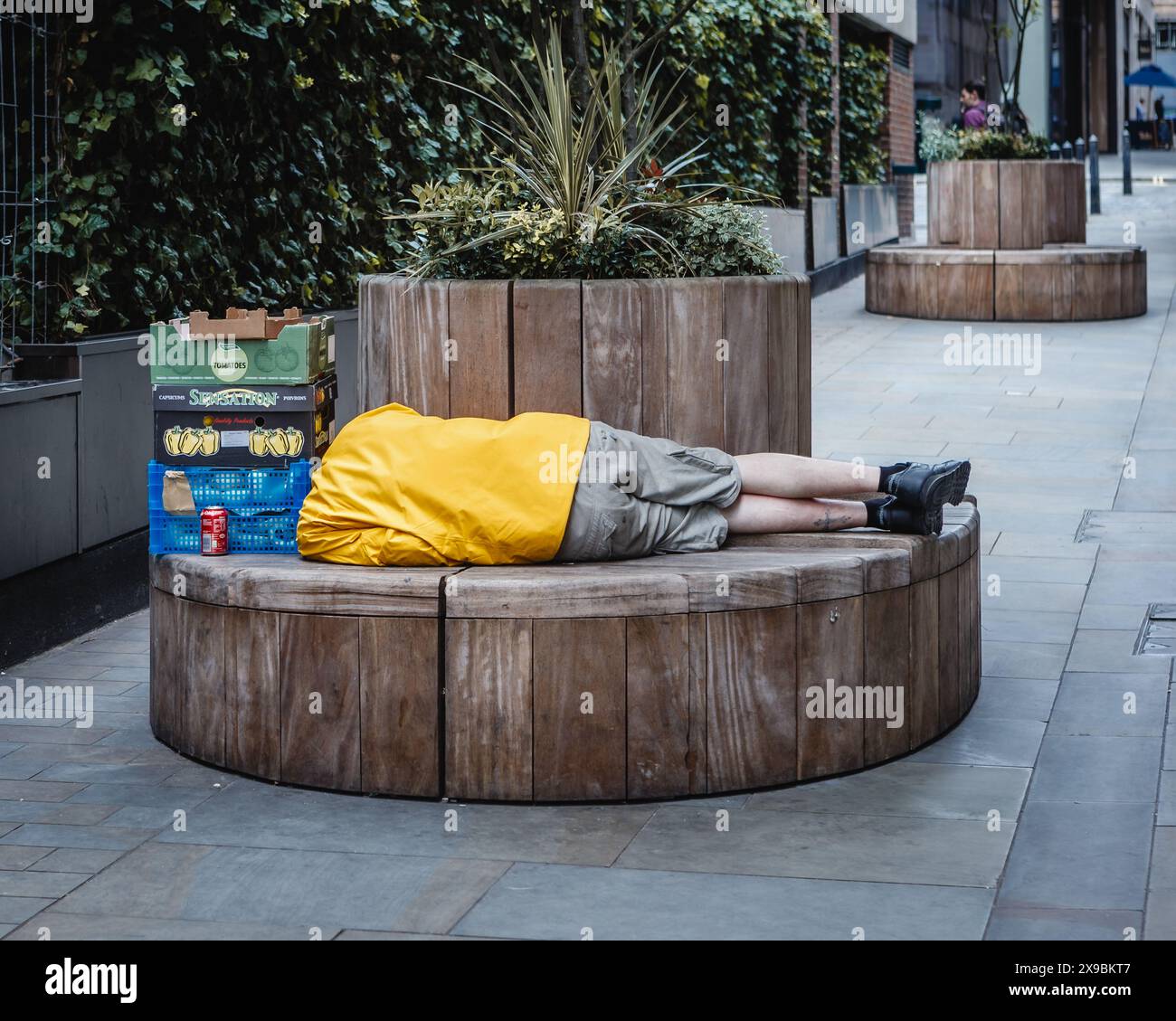 A man takes a nap on a bench in central London Stock Photo - Alamy