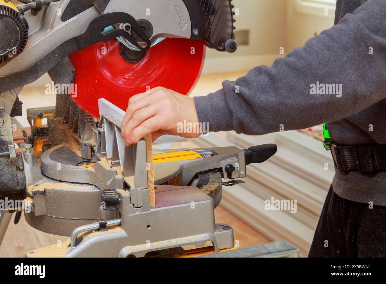 Contractor of using circular saw is cutting wooden moldings on circular ...