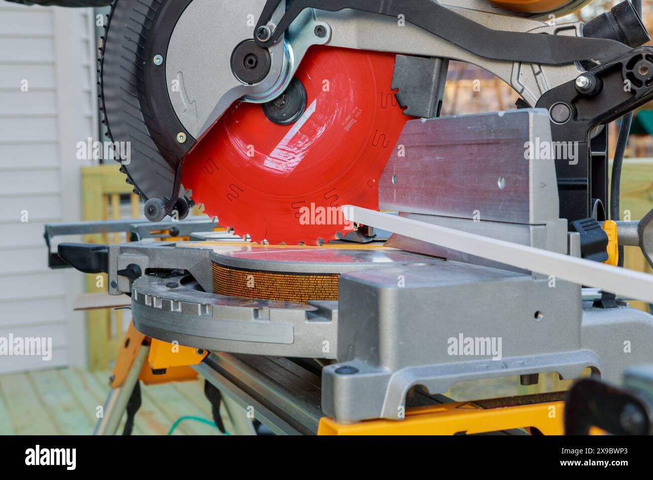 In this case, contractor is cutting wooden moldings with circular saw ...