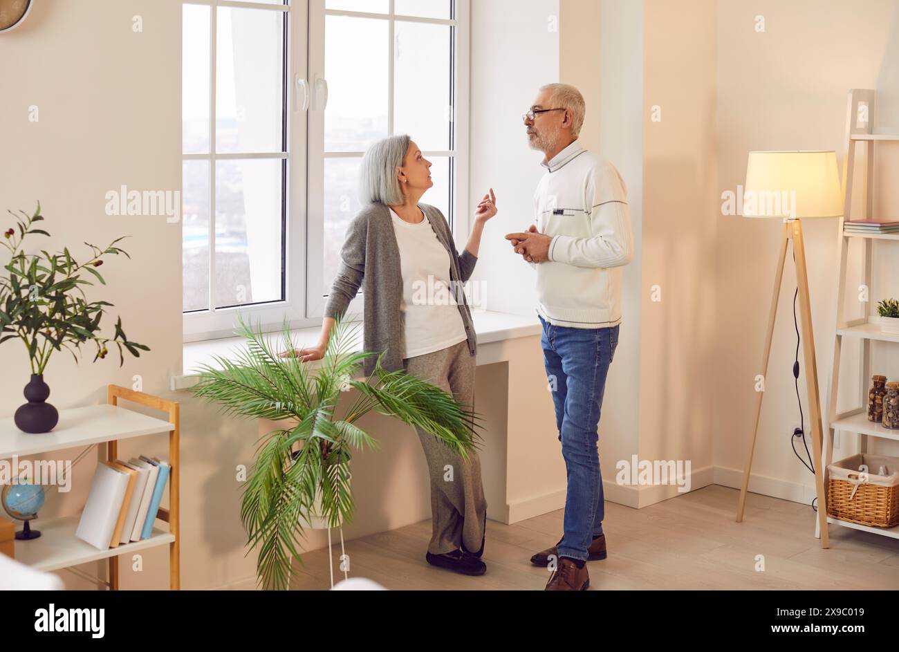 Elderly Couple Talking By The Window At Home Stock Photo - Alamy